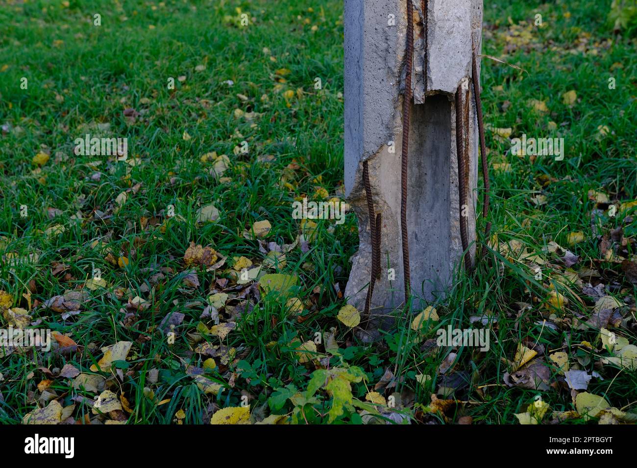 A close-up view of a dilapidated concrete column battered by an ...