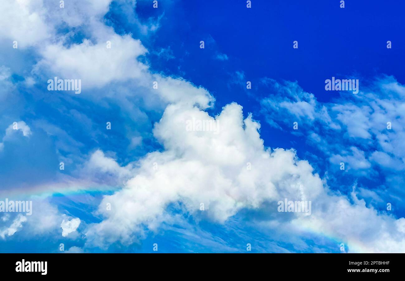 Beautiful and rare rainbow in cloudy sky and blue background in Tulum ...