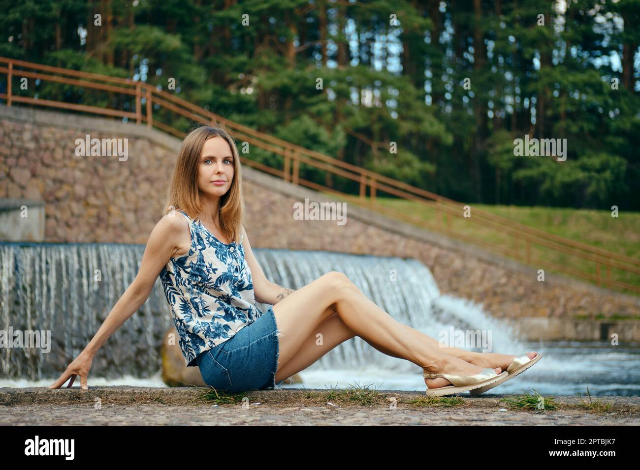 Girl in blouse and skirt having rest at country recreation area ...