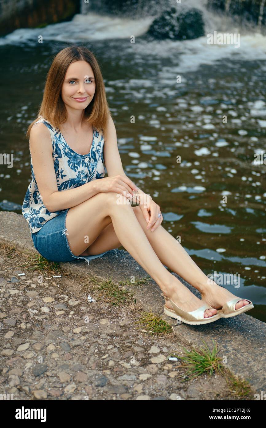 Girl in blouse and skirt having rest at country recreation area ...