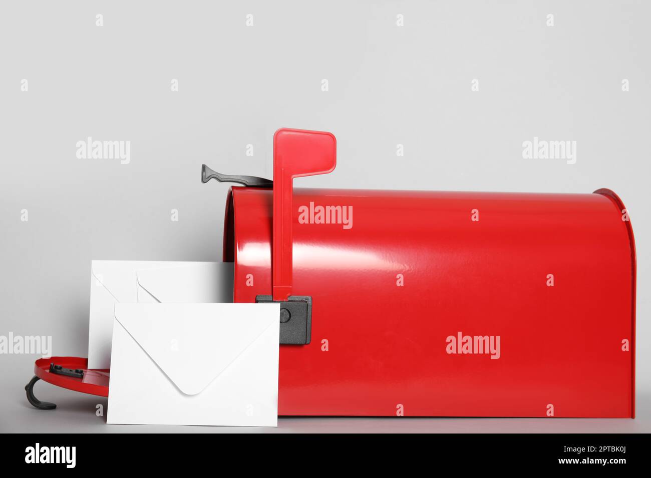Open red letter box with envelopes on light background Stock Photo - Alamy