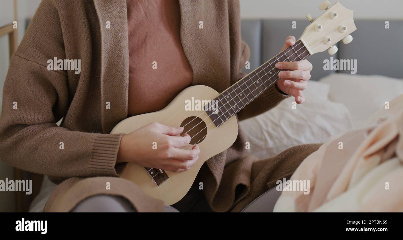 Woman play ukulele home hi-res stock photography and images - Alamy