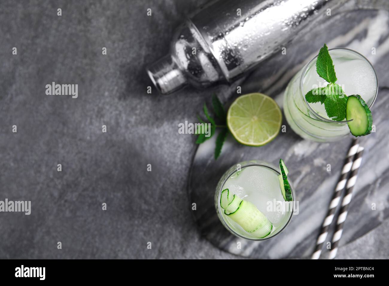 Glasses of refreshing cucumber water with ice on dark grey table, space for text Stock Photo - Alamy