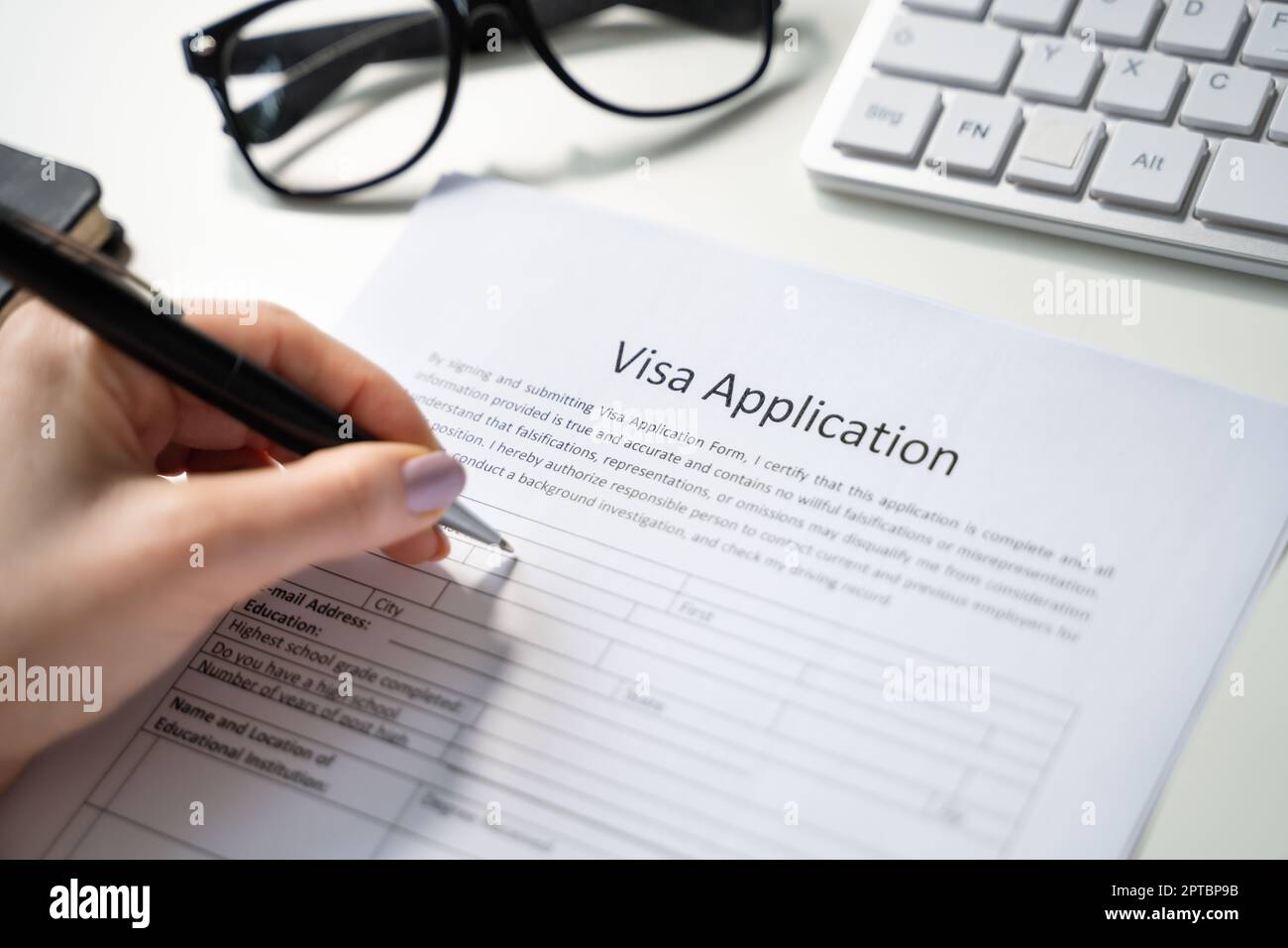 Person Hand Filling Visa Application Form On Desk Stock Photo - Alamy