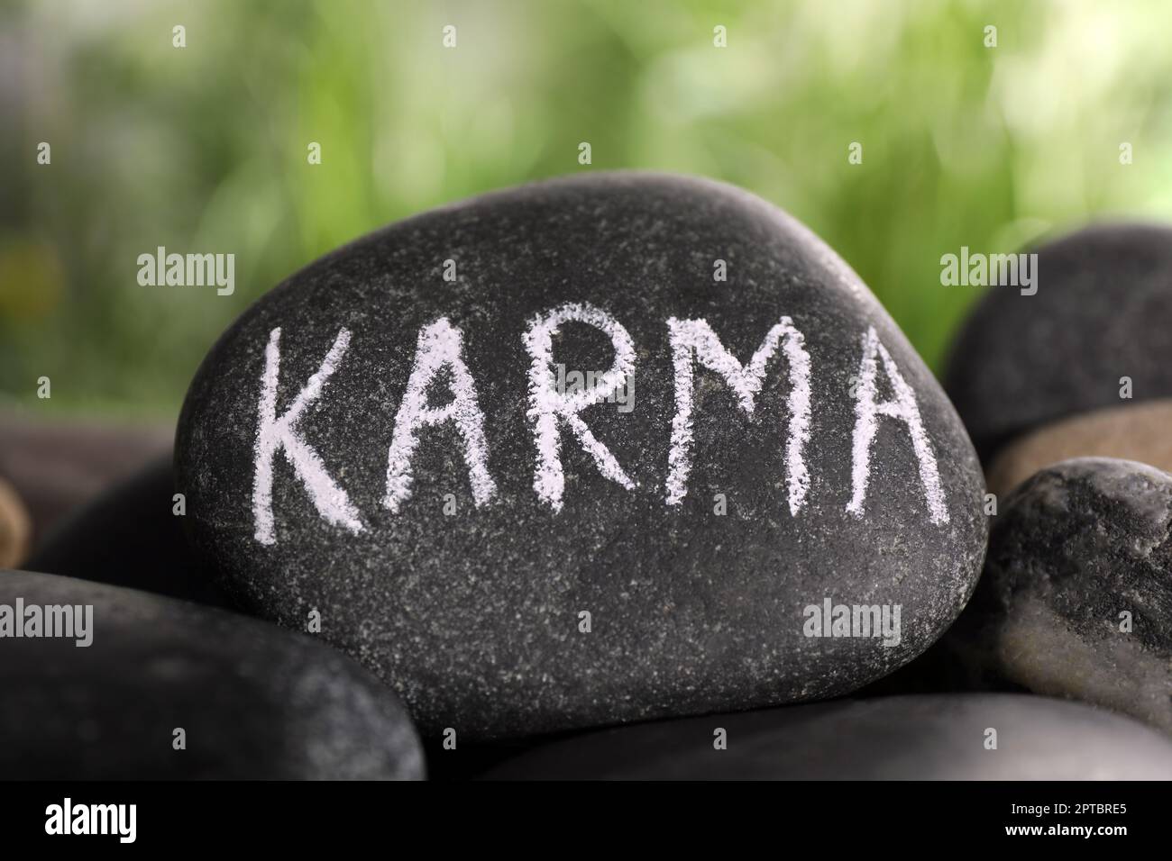 Stone with word Karma on blurred background, closeup Stock Photo - Alamy