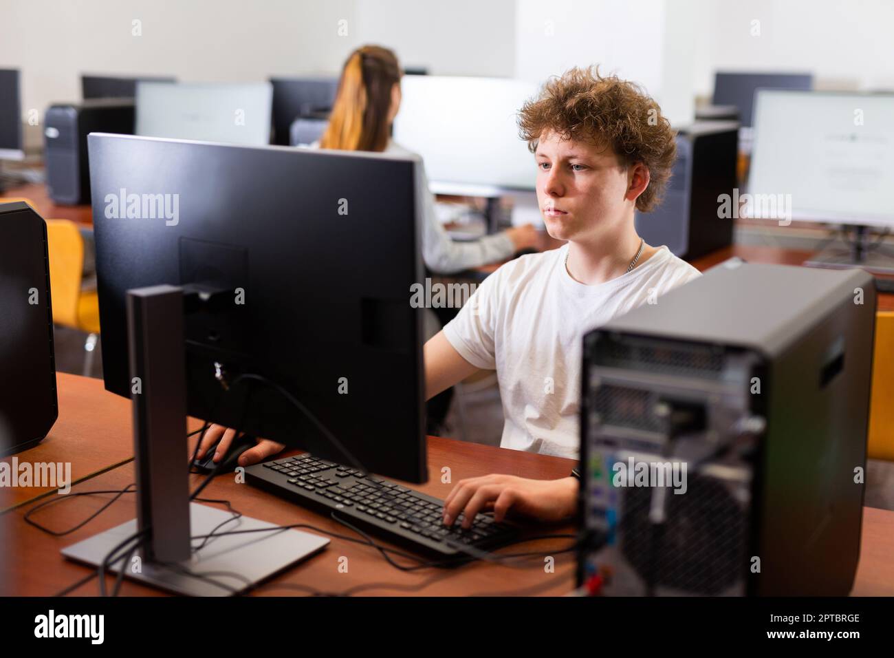 Teenage boy using computer during lesson Stock Photo - Alamy