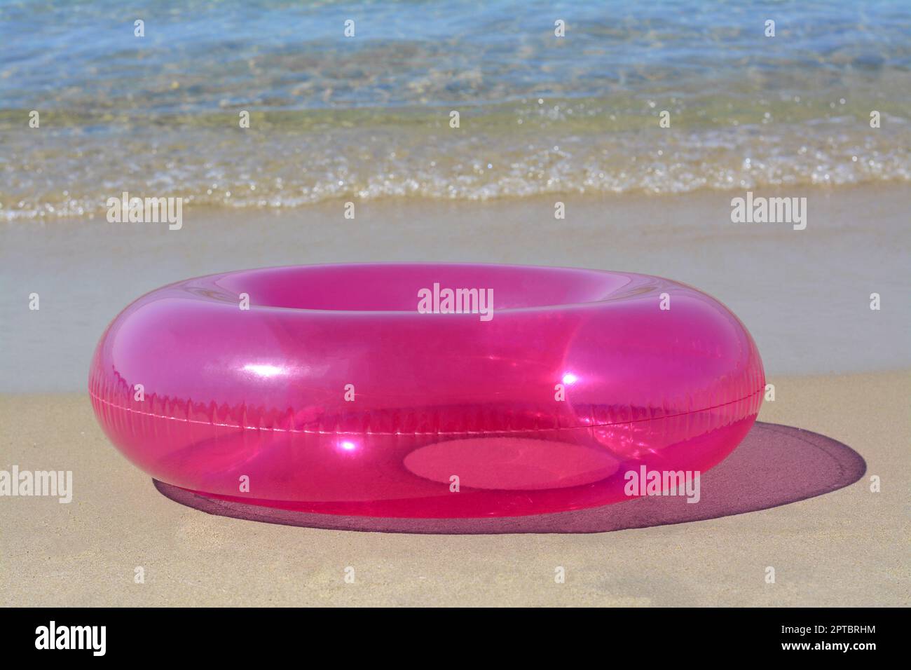 Bright inflatable ring on sandy beach near sea Stock Photo - Alamy