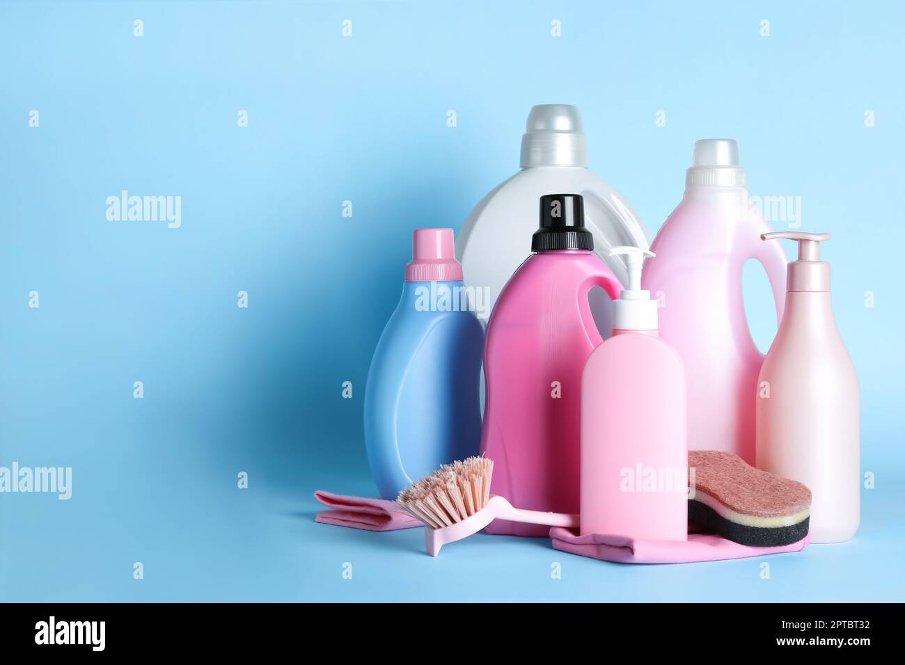 Different cleaning supplies and tools on light blue background, space ...
