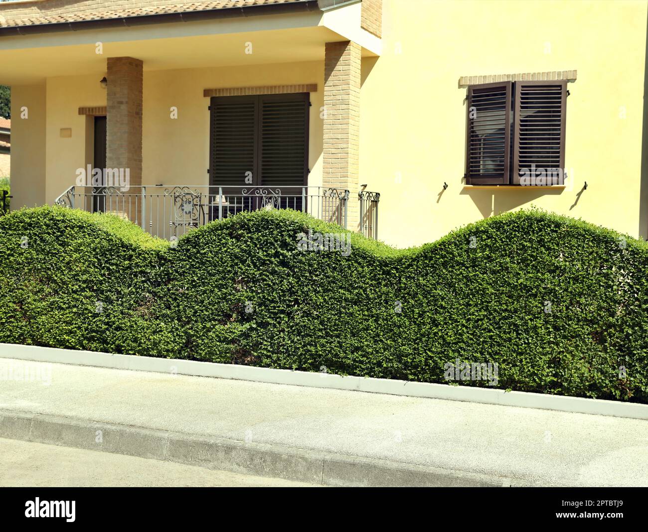 Residential building with beautiful green hedge on sunny day Stock ...