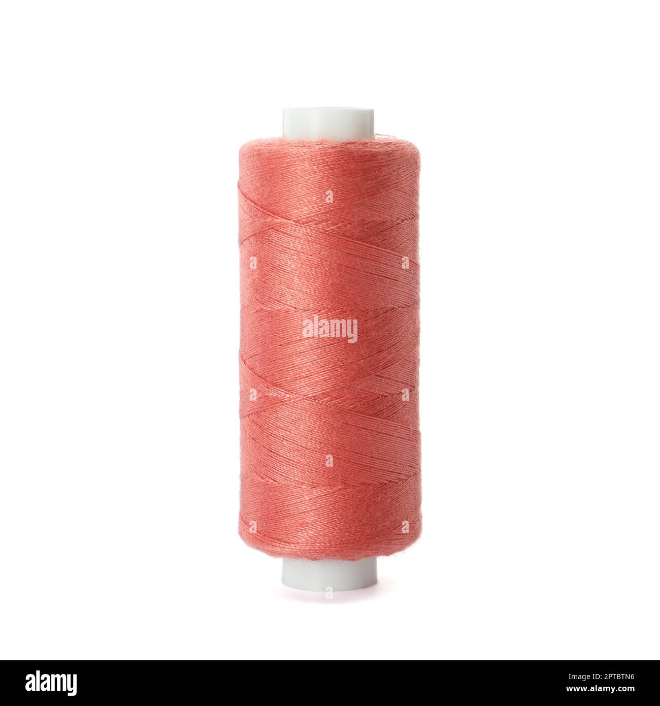 Spool of coral sewing thread isolated on white Stock Photo - Alamy