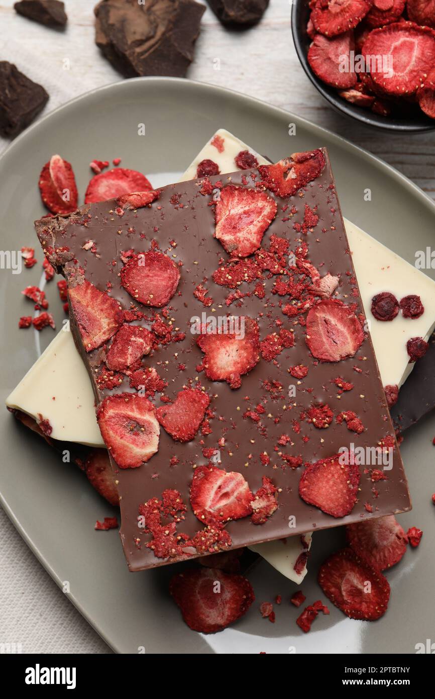 Plate and different chocolate bars with freeze dried fruits on white ...