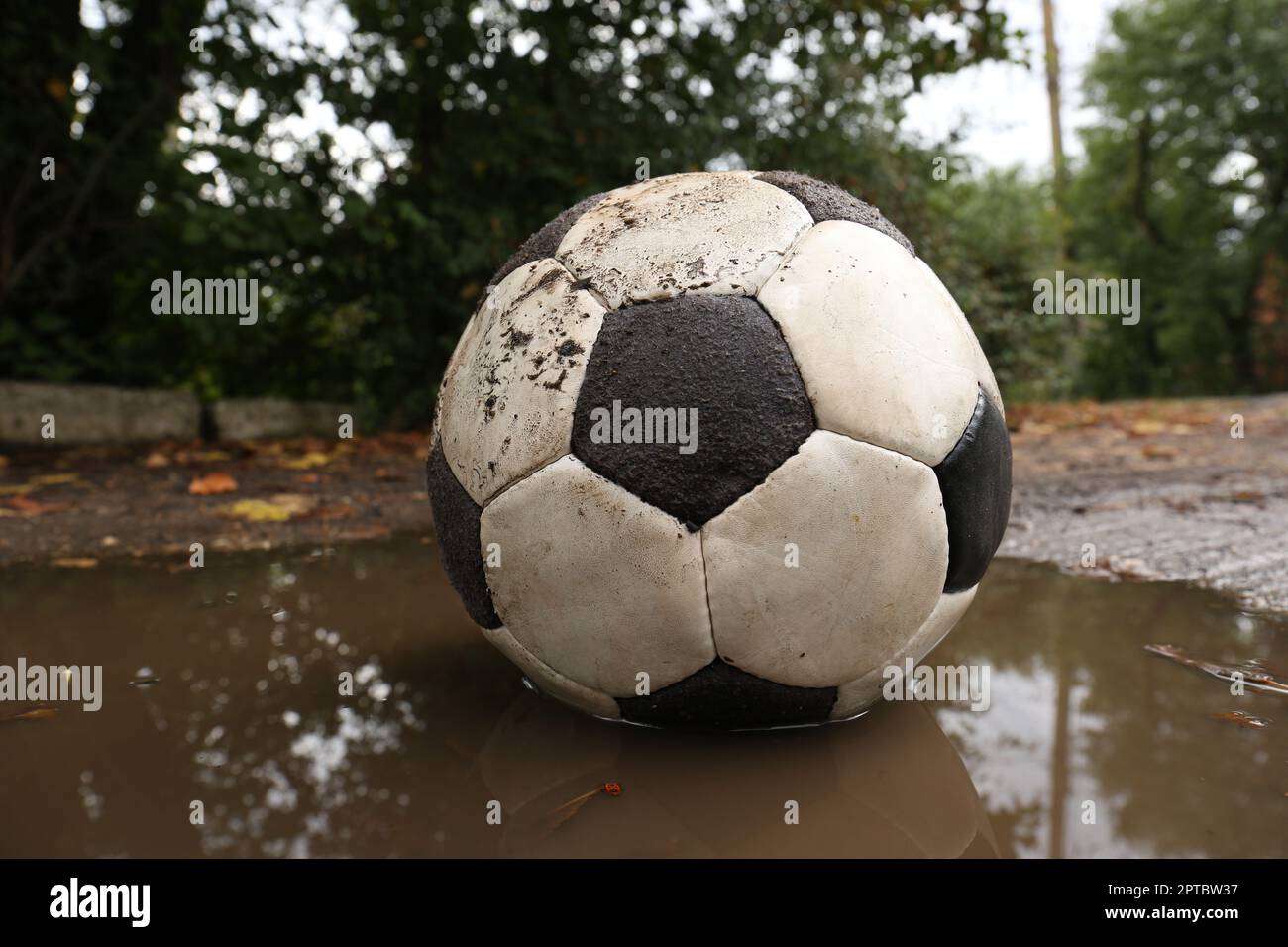 Dirty soccer ball in muddy puddle, closeup Stock Photo - Alamy