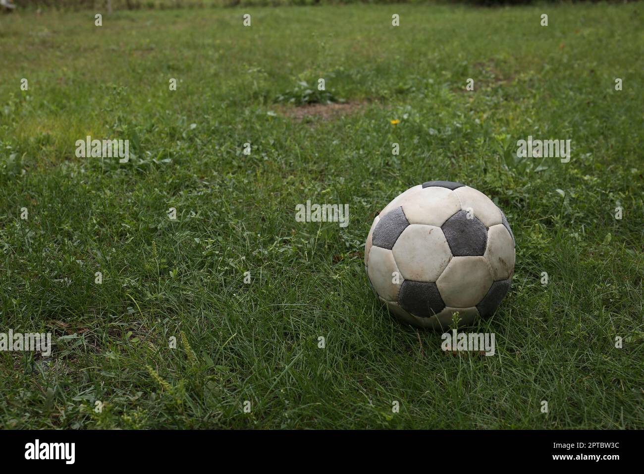 Dirty soccer ball on green football field, space for text Stock Photo ...