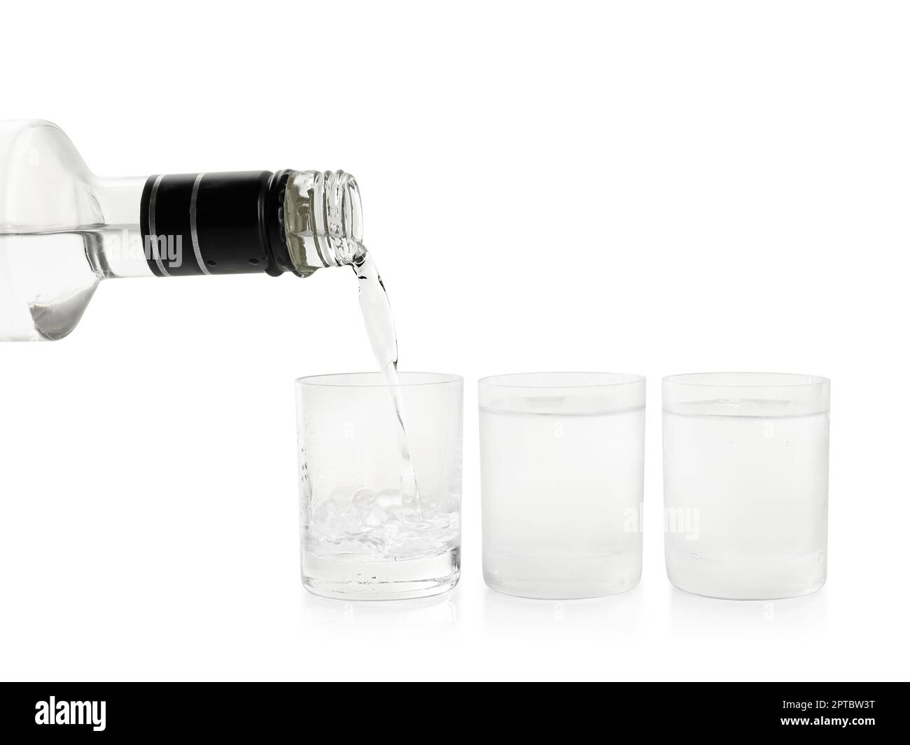 Pouring vodka from bottle in glass on white background Stock Photo - Alamy