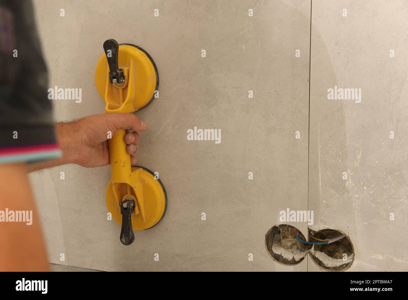 Worker installing wall tiles with vacuum holder, closeup Stock Photo ...