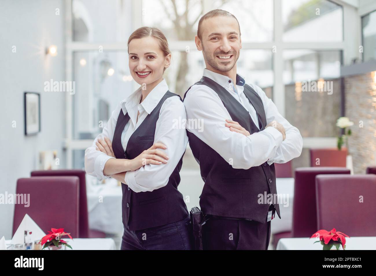 Team of woman and man waiter in a restaurant standing shoulder to ...