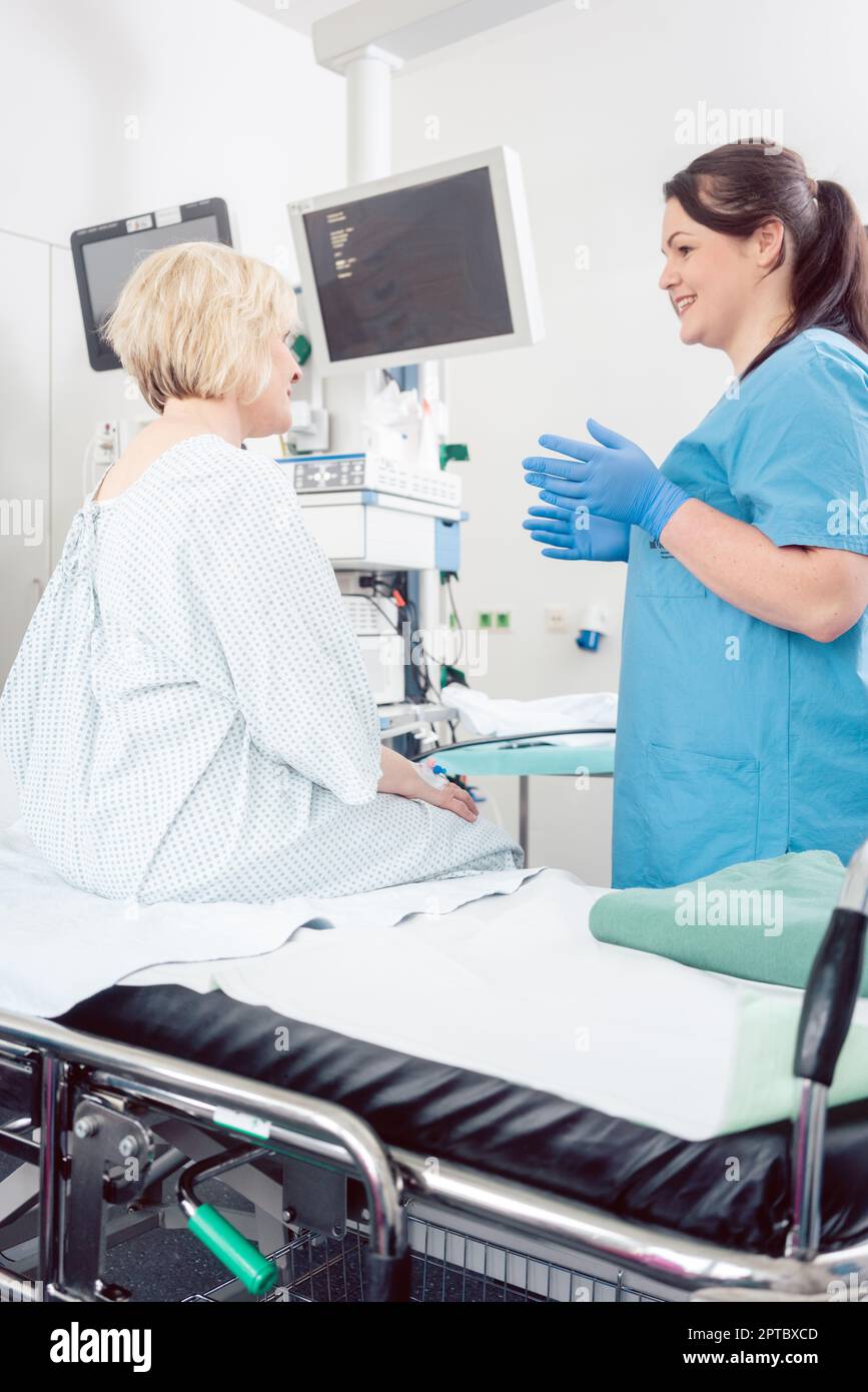 Nurse explaining procedure to patient in hospital surgery to ease ...
