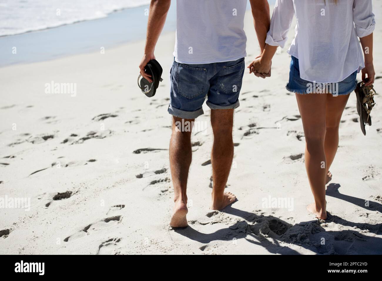 Walking side by side. Cropped image of a couple walking on the beach ...