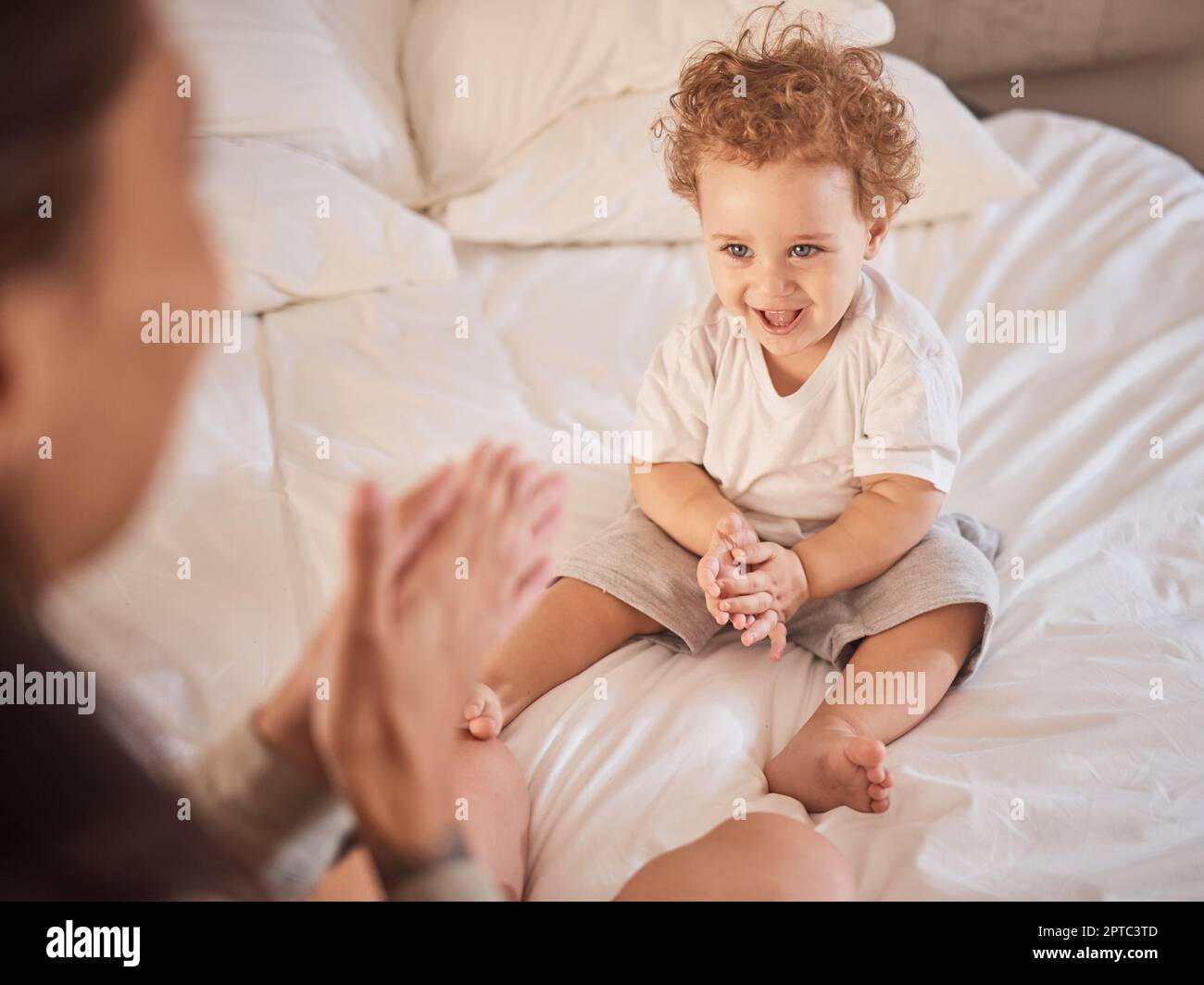 Baby, family and child clapping hands, happy and having fun on bed ...