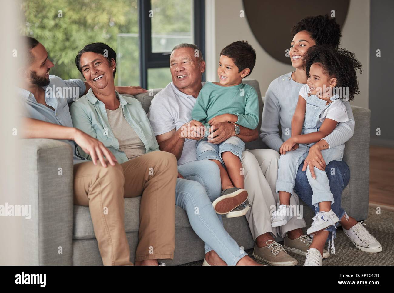 Children, parents and happy grandparents on sofa, generations of family ...