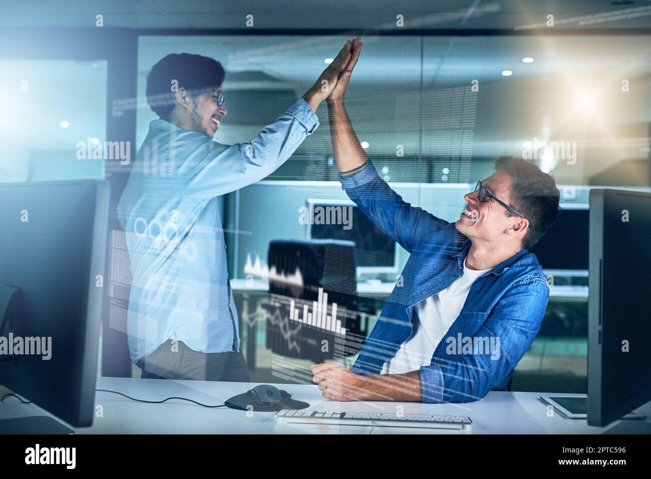 Every day is a victory. two young male programmers working on a computer together while giving ...