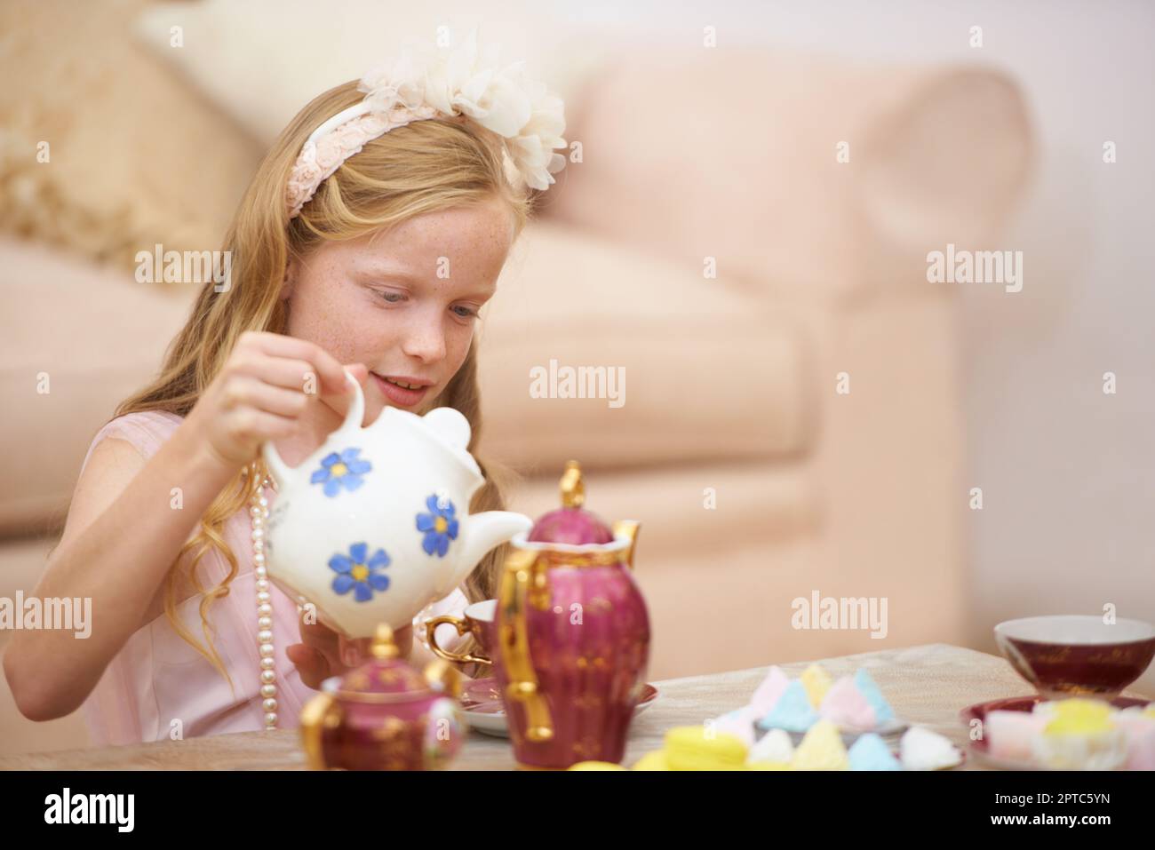 Having the perfect tea party. A cute little girl playing at having a ...