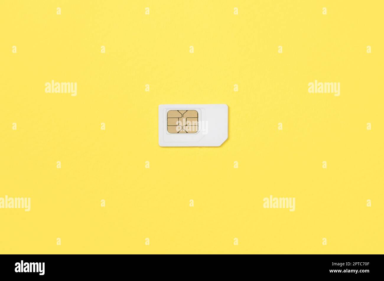 Subscriber identity module. New white SIM card on bright yellow color ...