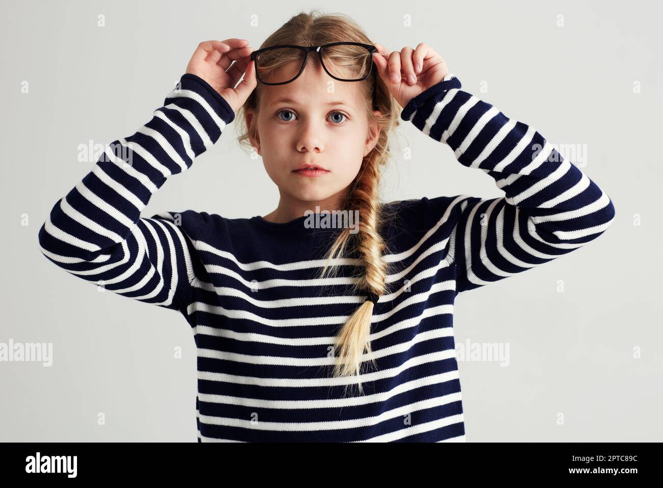 These glasses are just for show. Portrait of a cute girl lifting her ...