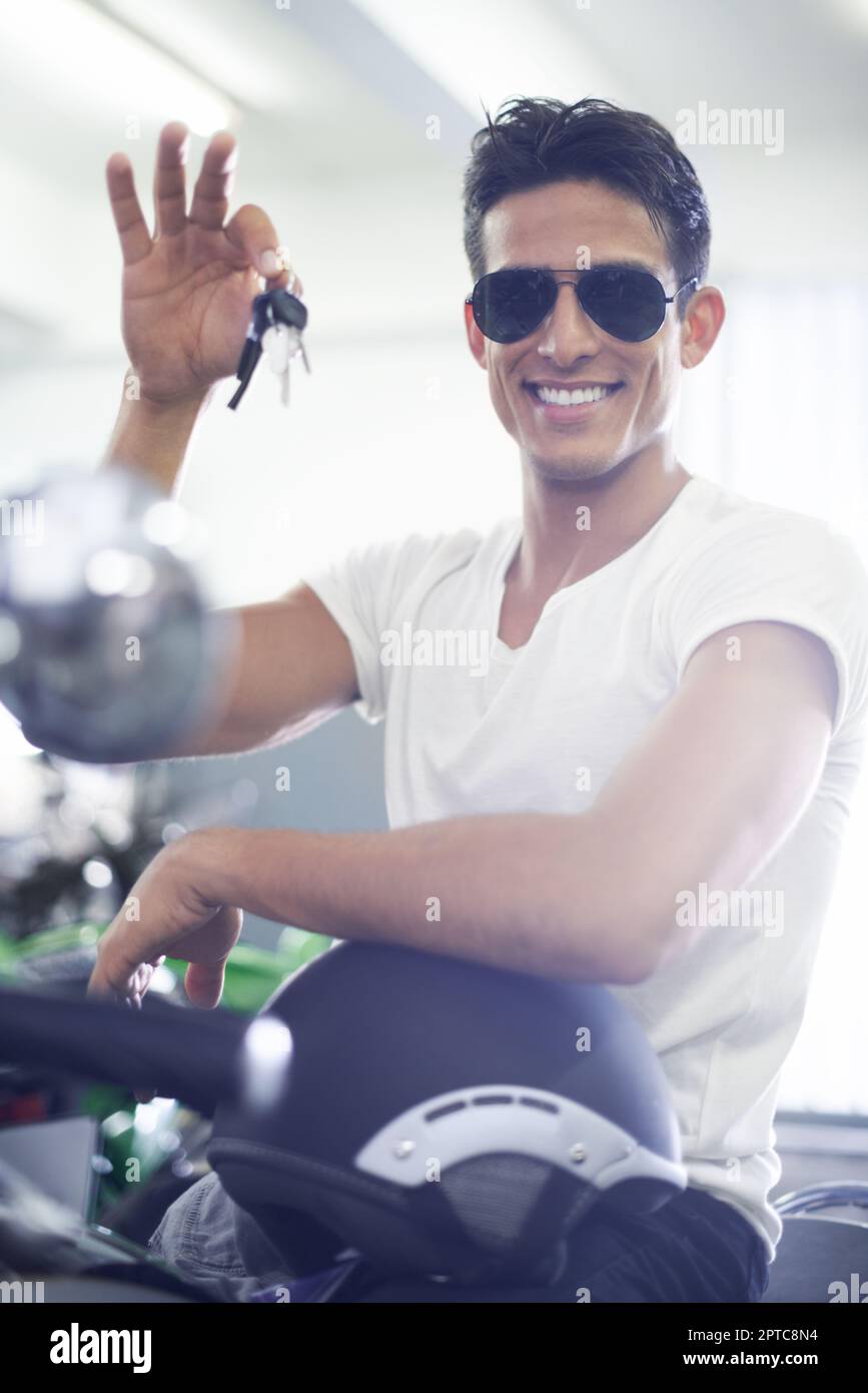 Lets get out of here. A handsome young man sitting on his motorcycle ...