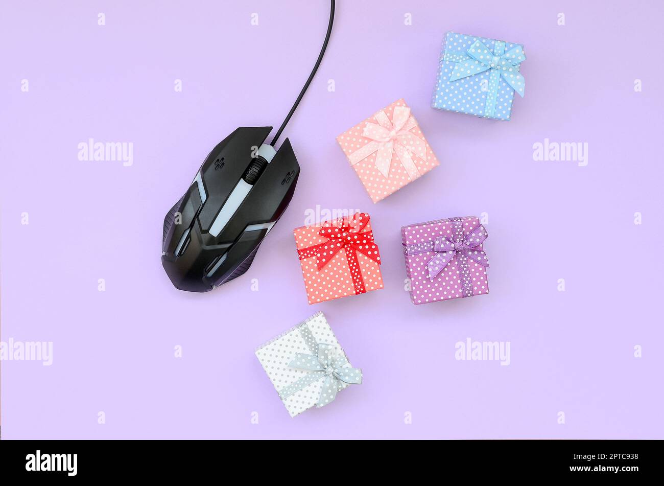 Computer mouse and lots of gift boxes on a purple background. Online ...