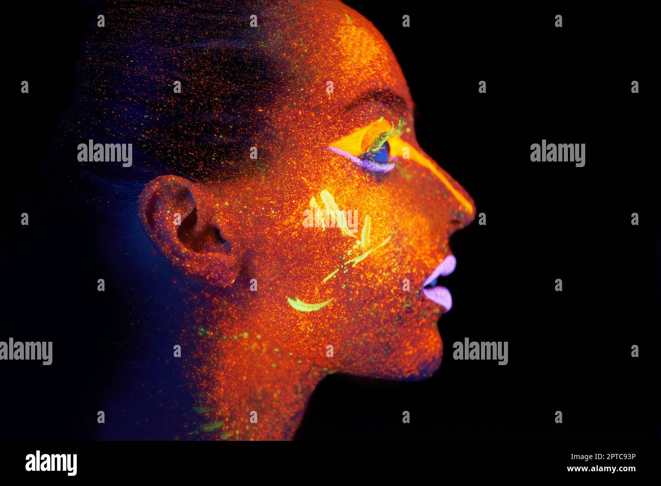 Neon profile. Side view of a young woman with neon pain on her face ...