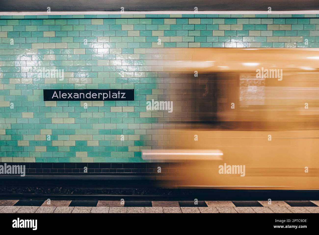 Yellow subway train in Motion. Berlin Alexanderplatz sign visible on ...