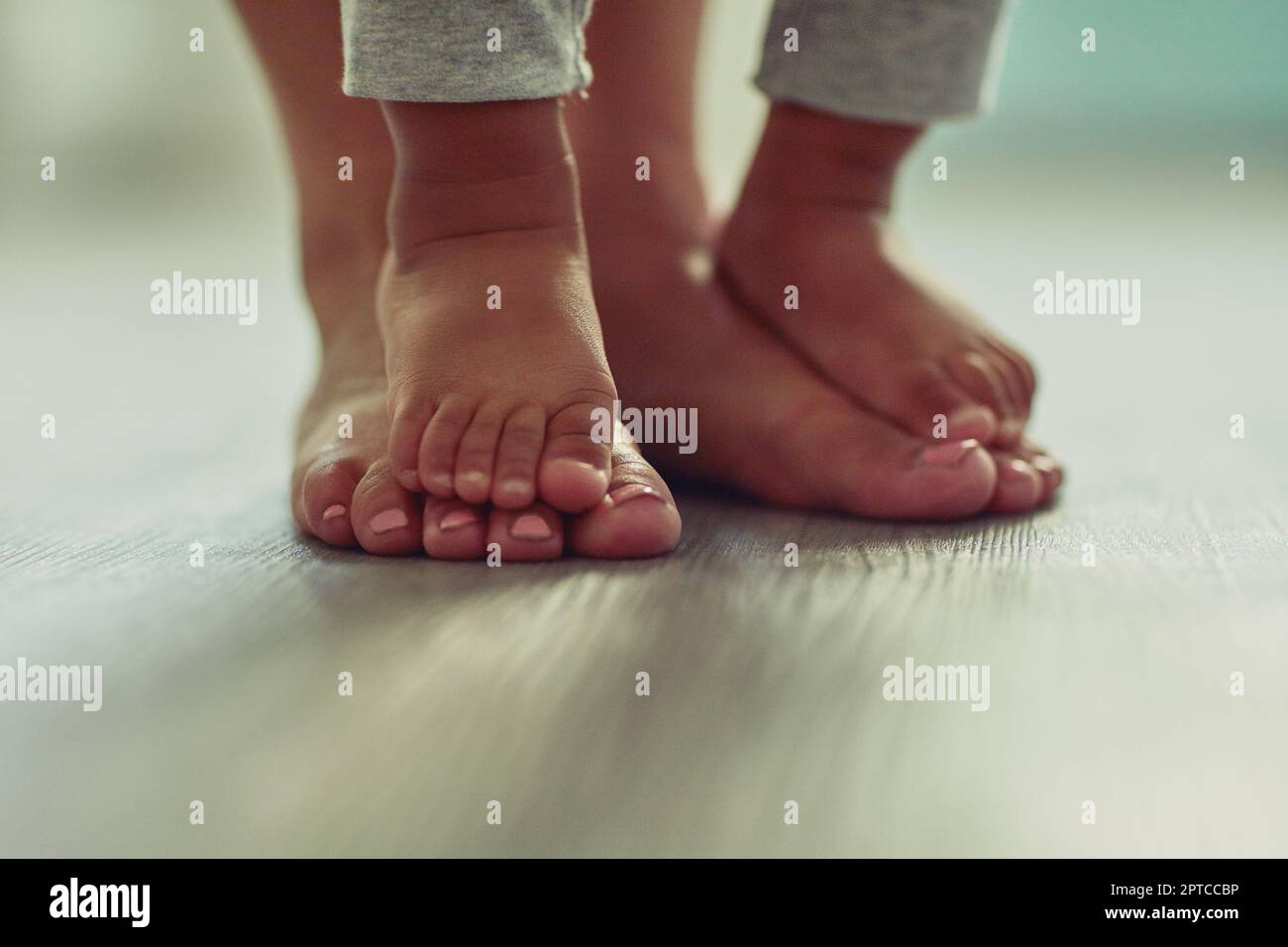 Tiny feet will one day become big, cherish these moments. an unrecognizable mothers feet and her ...