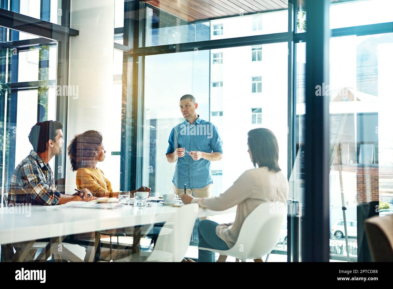 Briefing his team in the boardroom. a young businessman giving a ...