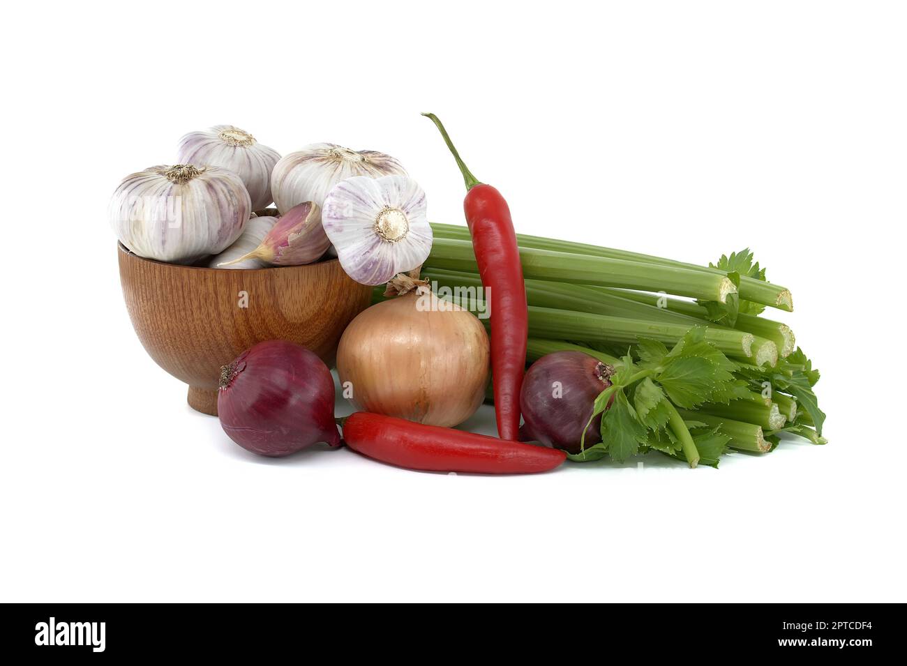 Onions, chili pepper and garlic bulbs in wooden bowl in front of fresh ...
