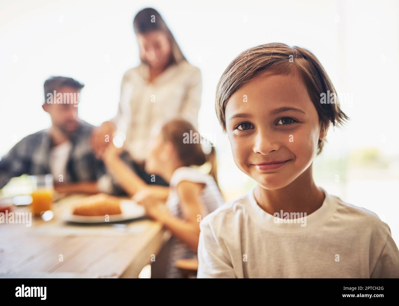 Starting the day together. Portrait of a little boy having breakfast ...
