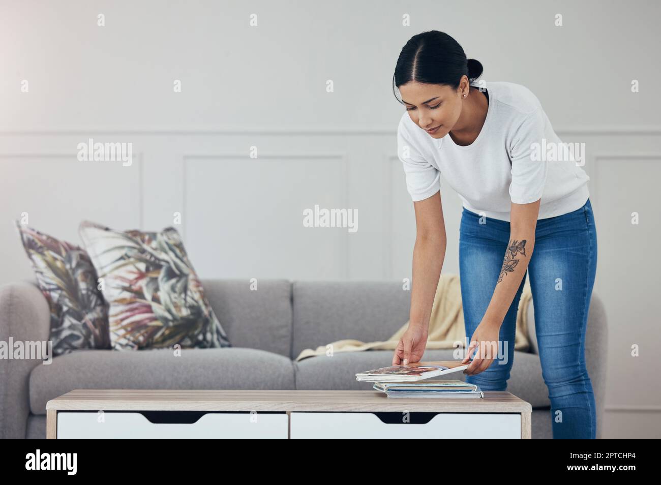 Cleaning, living room books and hygiene woman tidy apartment, home or ...
