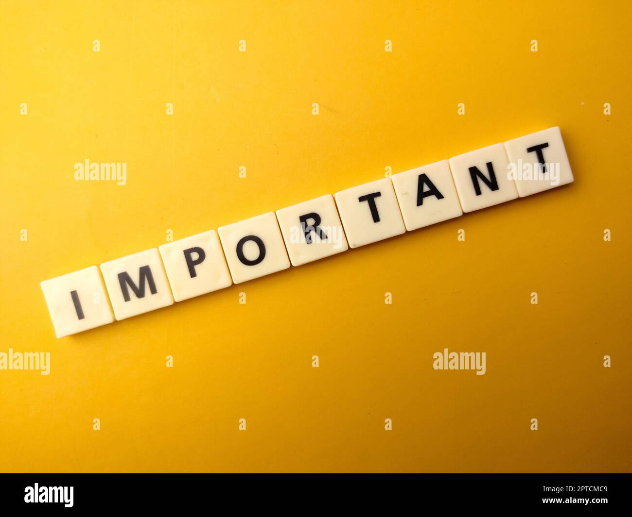 Top view toy word with the word IMPORTANT on yellow background Stock ...