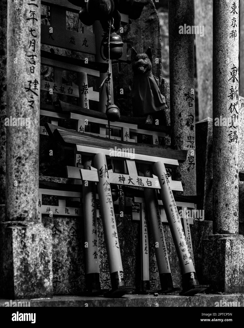 A black and white picture of stacked miniature torii gates at the ...