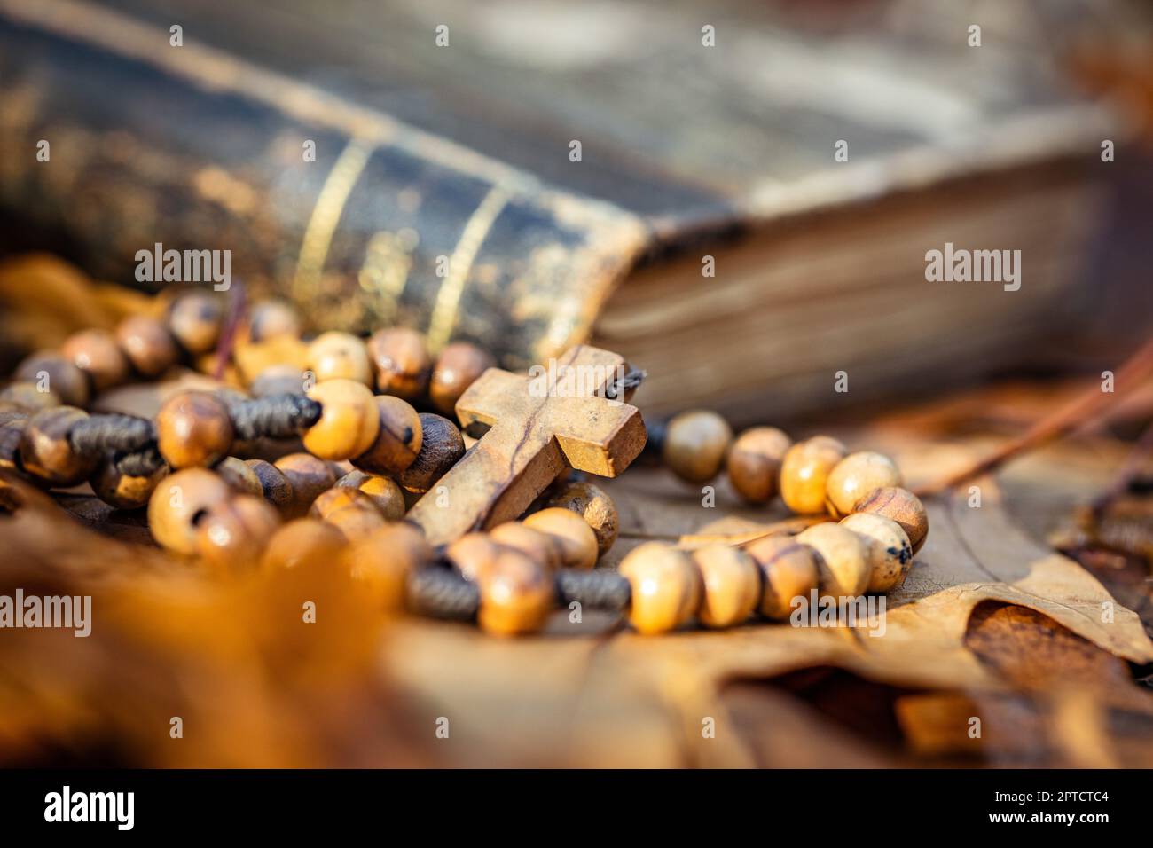 Wooden rosary beads and holy bible book lying on the autumn leaves ...