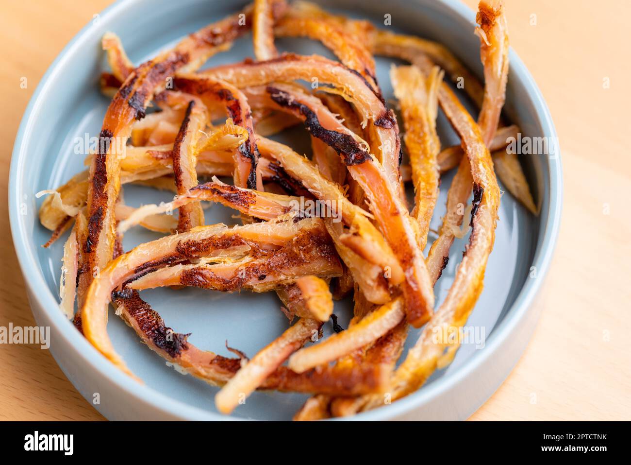 Dried squid snack in the plate Stock Photo - Alamy
