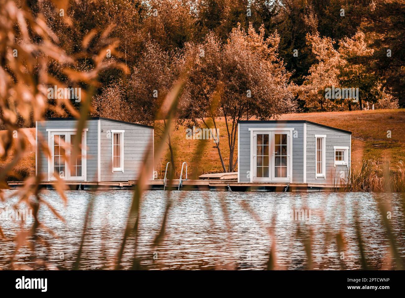 Couple of floating grey cabins on the lake. Living on a floating house ...