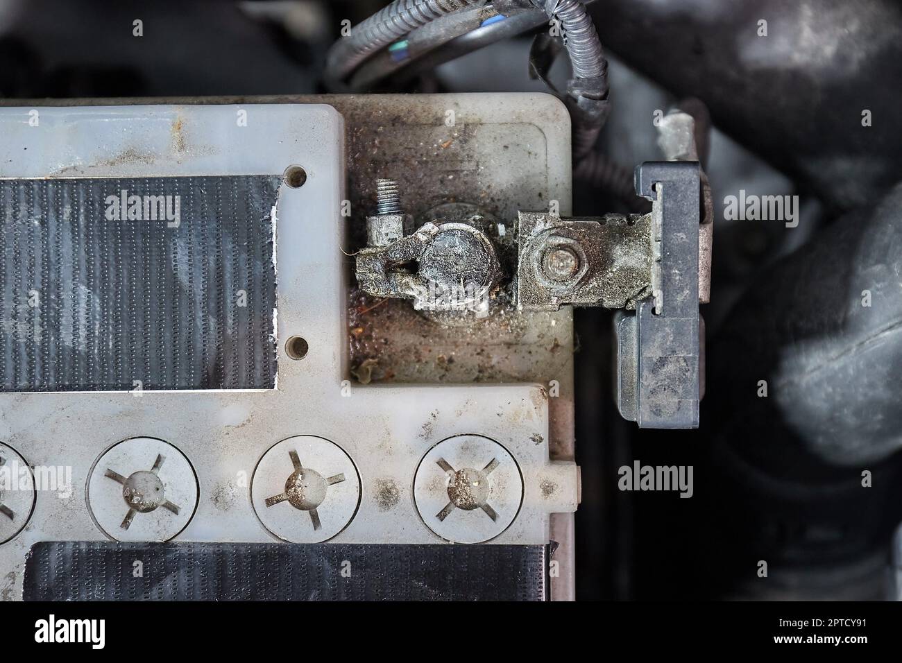 Old car starter battery inside the engine bay viewed from above top ...