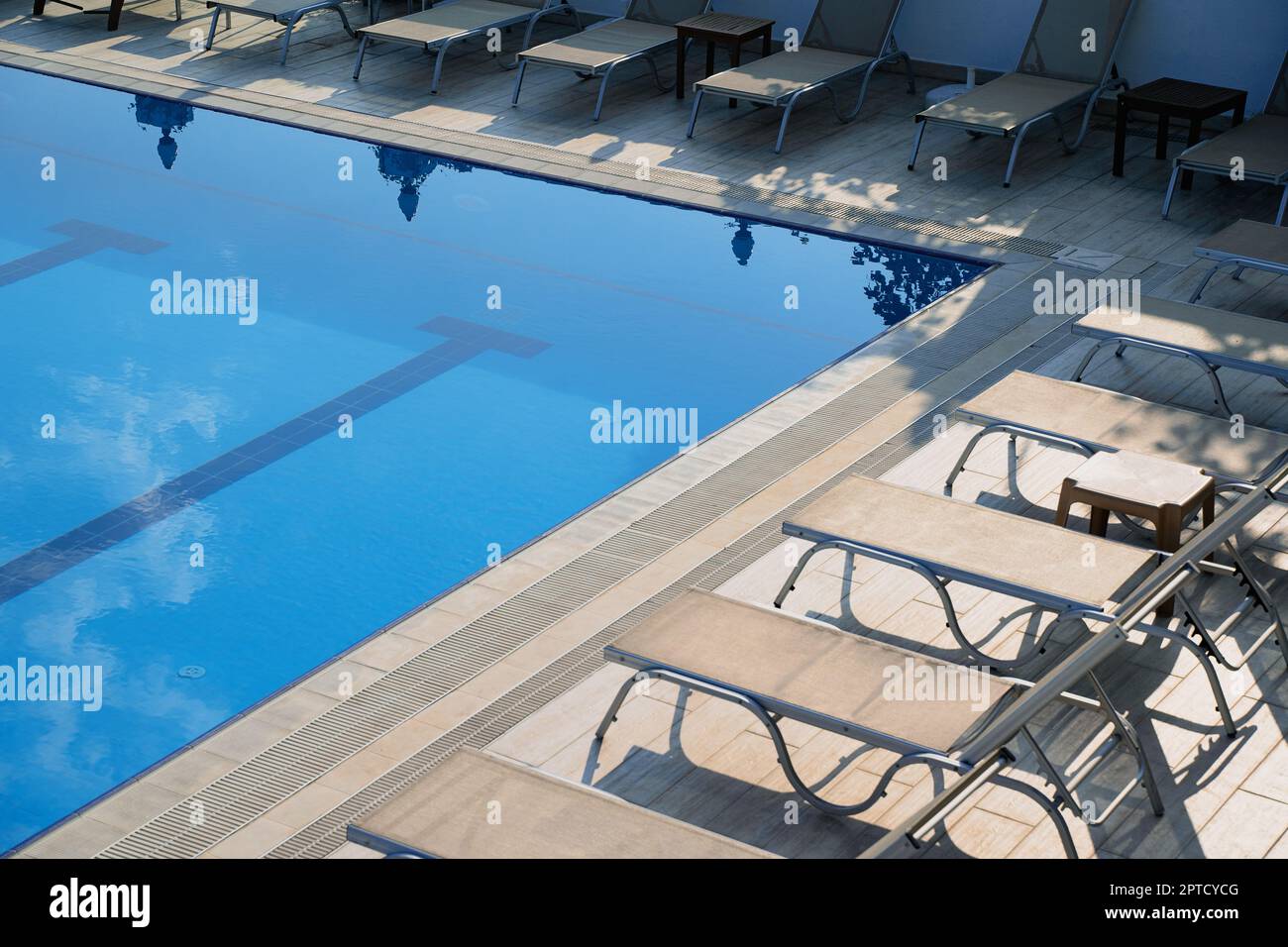 top view closeup detail of sunlounger chairs near an outdoor pool and ...