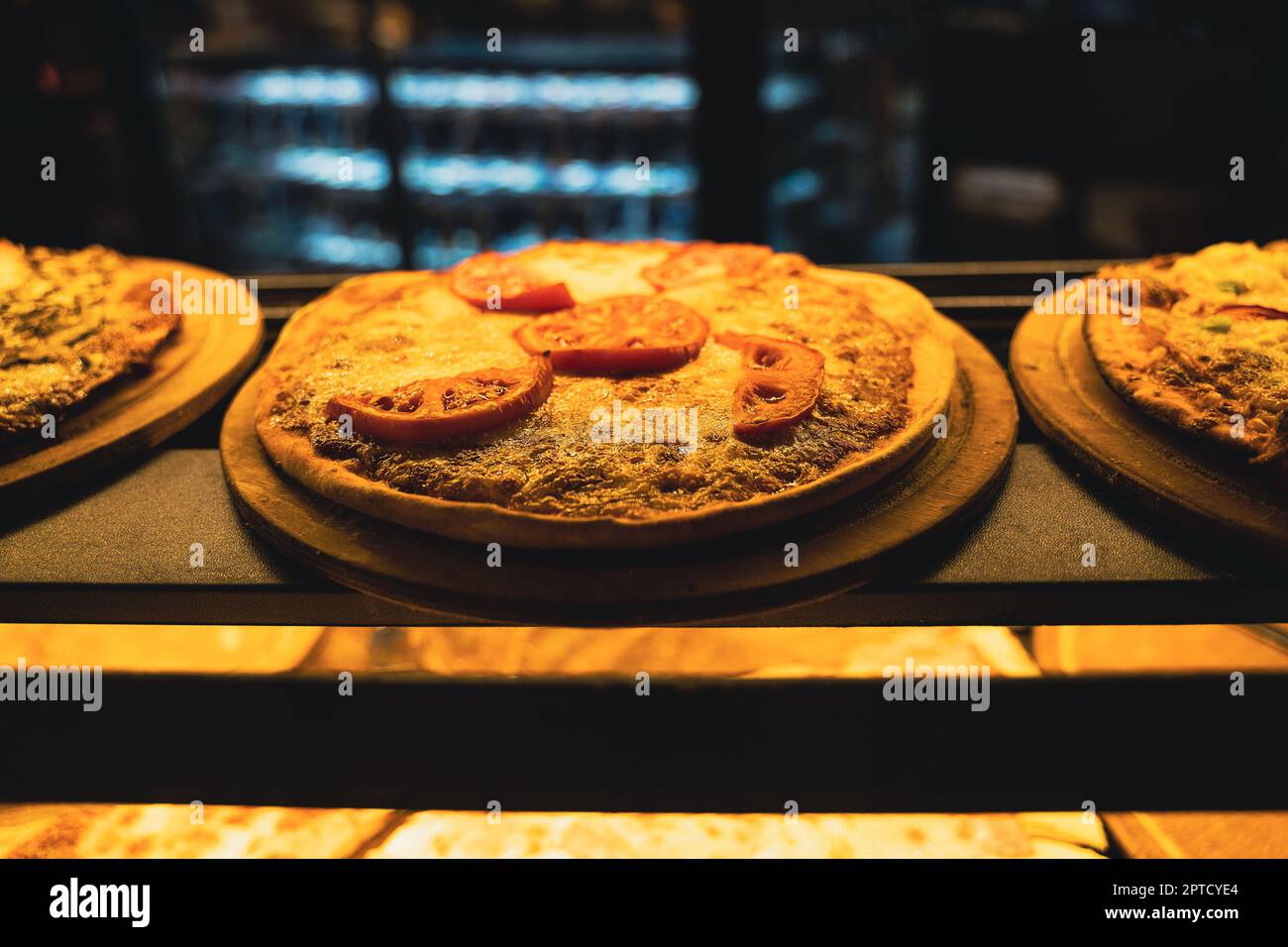 perspective view closeup of different kinds of pizza on wooden plates ...