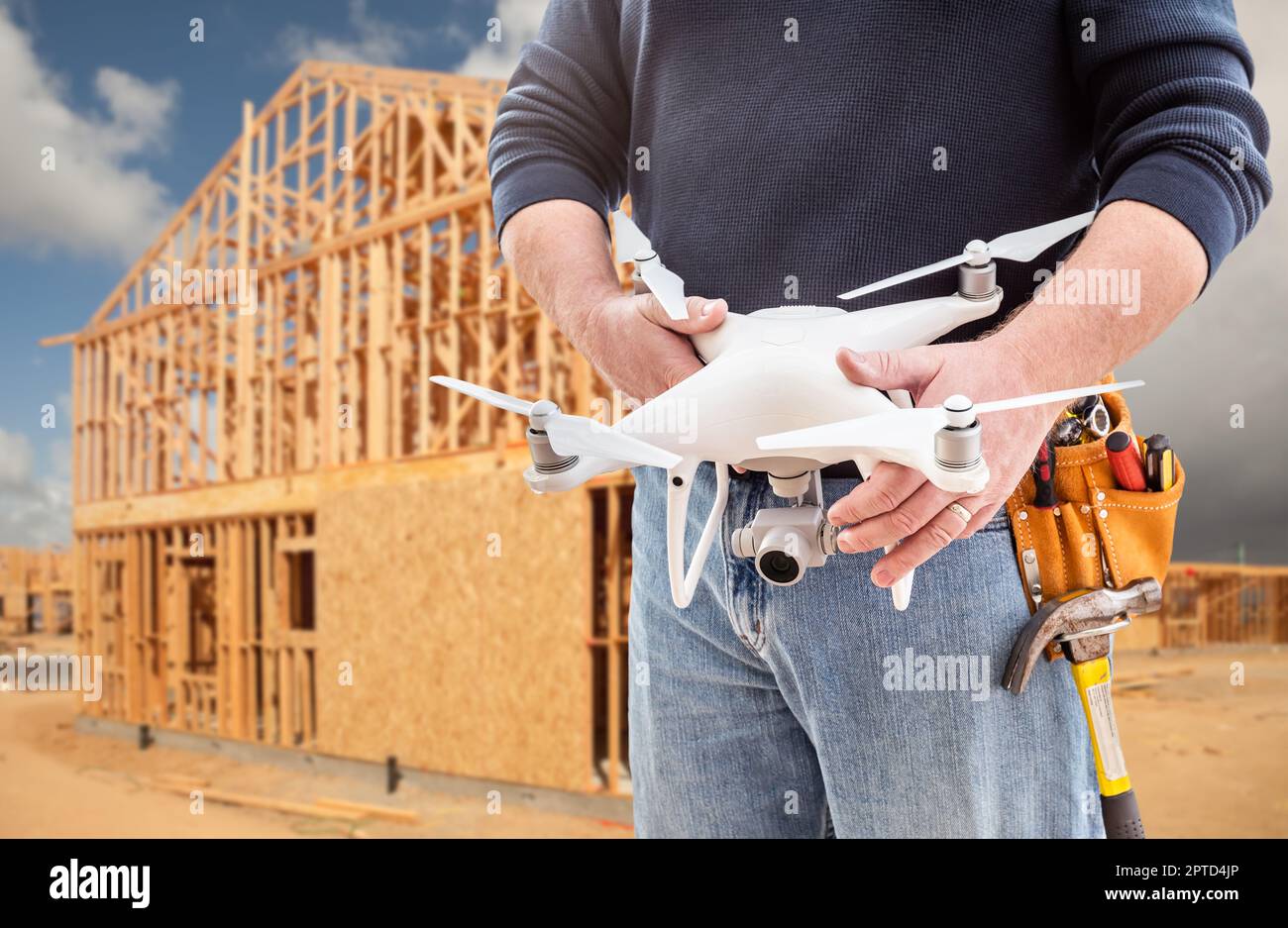 Construction Worker and Drone Pilot With Toolbelt Holding Drone At ...