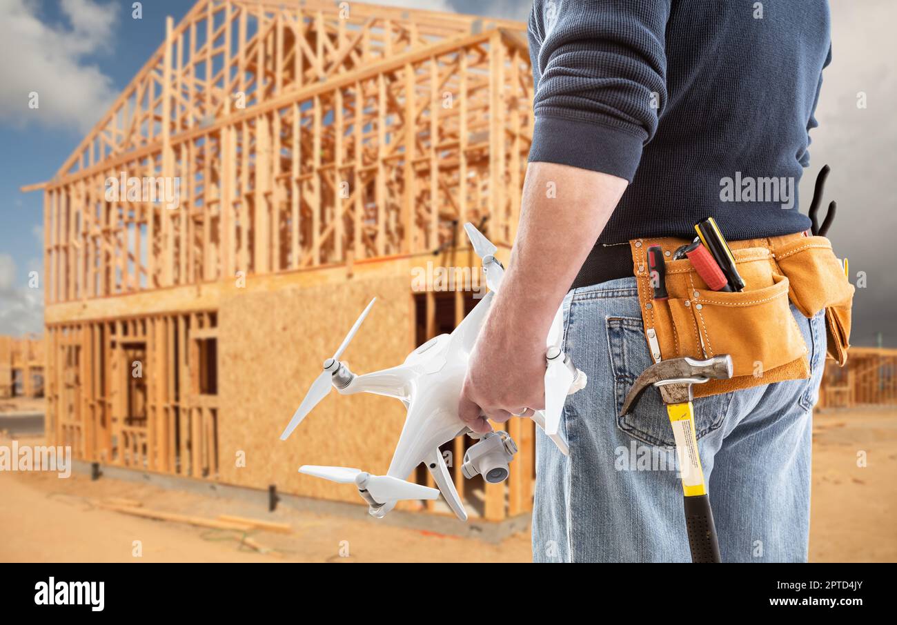 Construction Worker and Drone Pilot With Toolbelt Holding Drone At ...