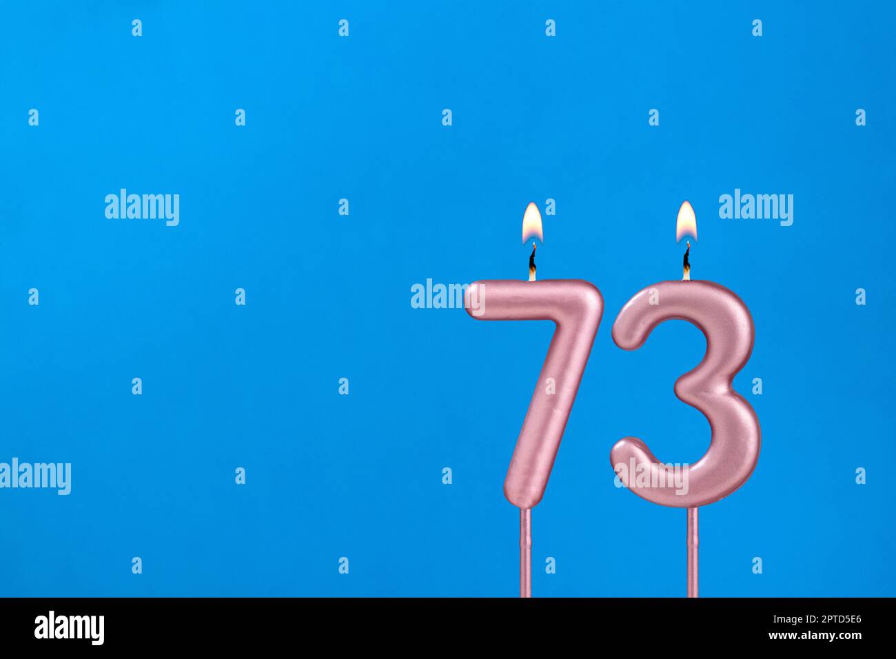 Number 73 - Burning anniversary candle on blue foamy background Stock ...
