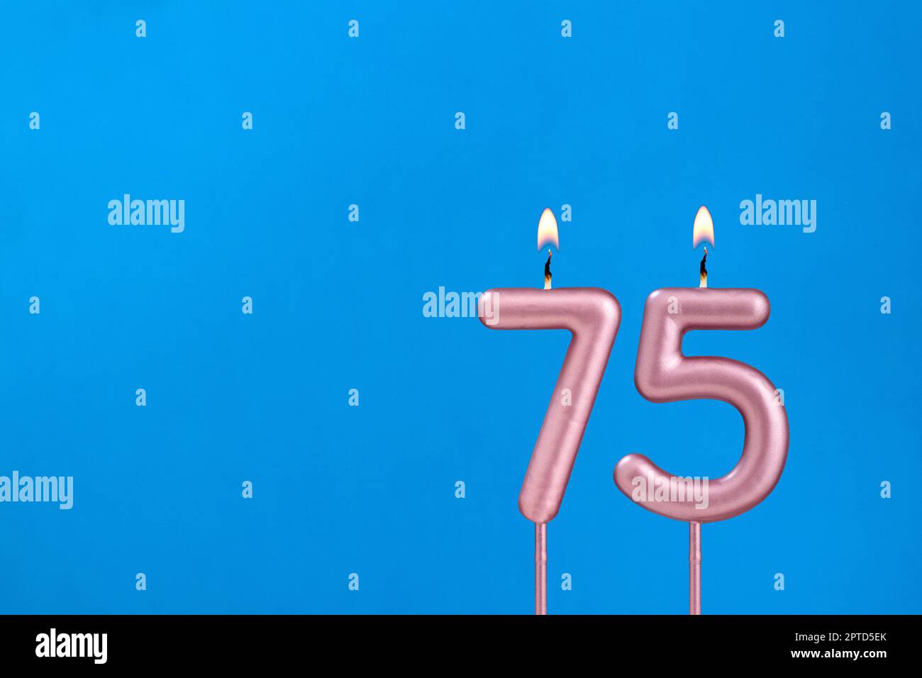 Number 75 - Burning anniversary candle on blue foamy background Stock ...
