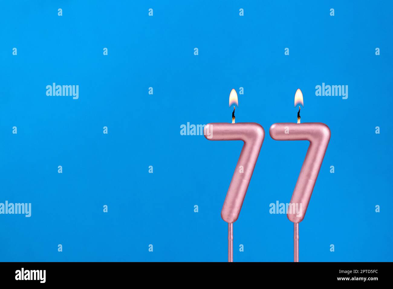 Number 77 - Burning anniversary candle on blue foamy background Stock ...